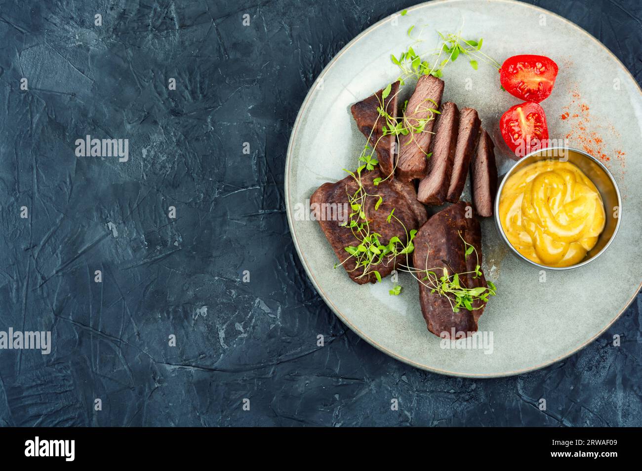 Roasted ostrich meat steaks with sauce. African cuisine. Copy space ...