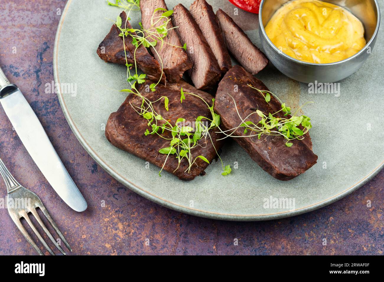 Delicious ostrich meat steaks with sauce. African cuisine Stock Photo ...