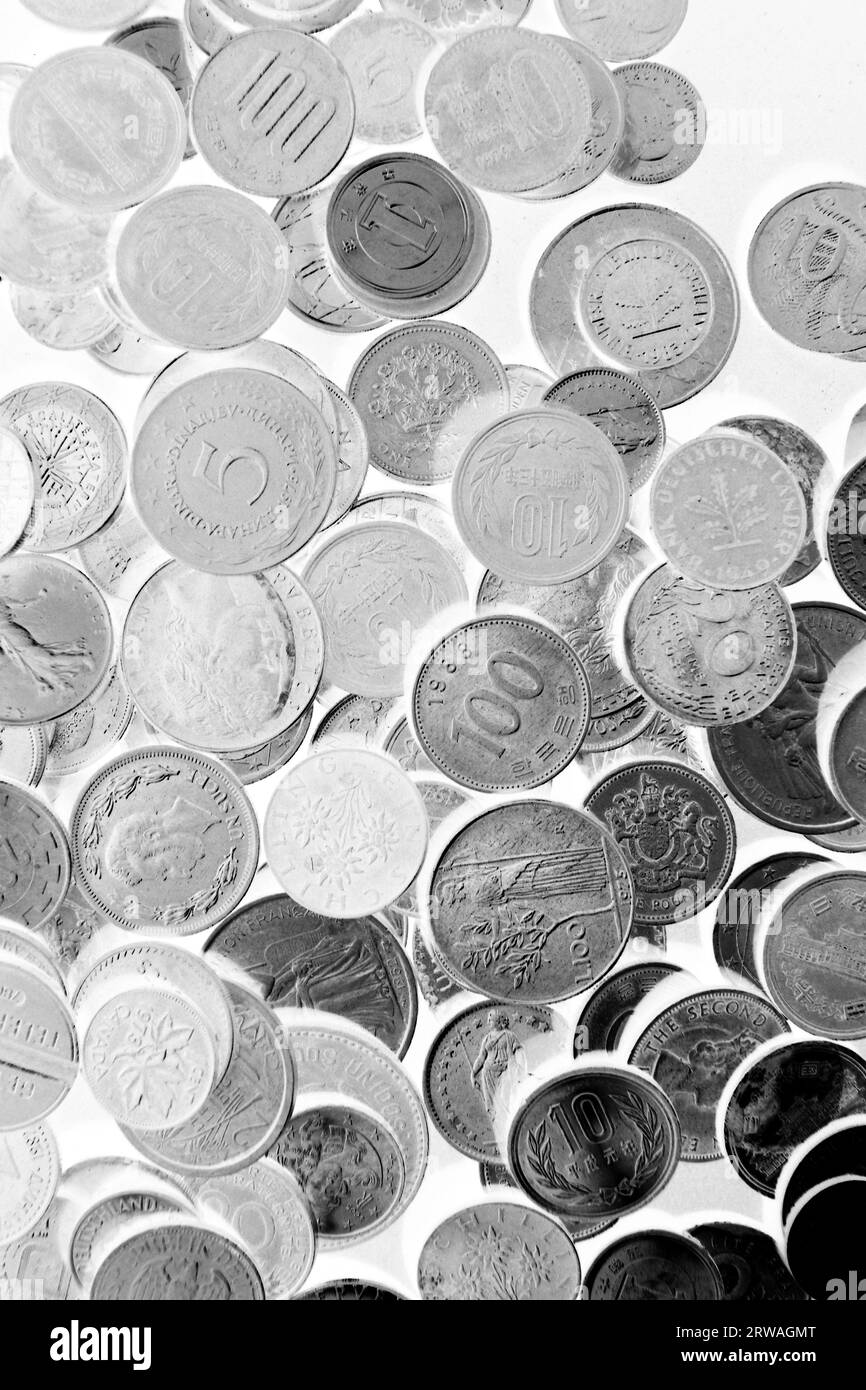 A collection of international coins and currency in a black and white ...