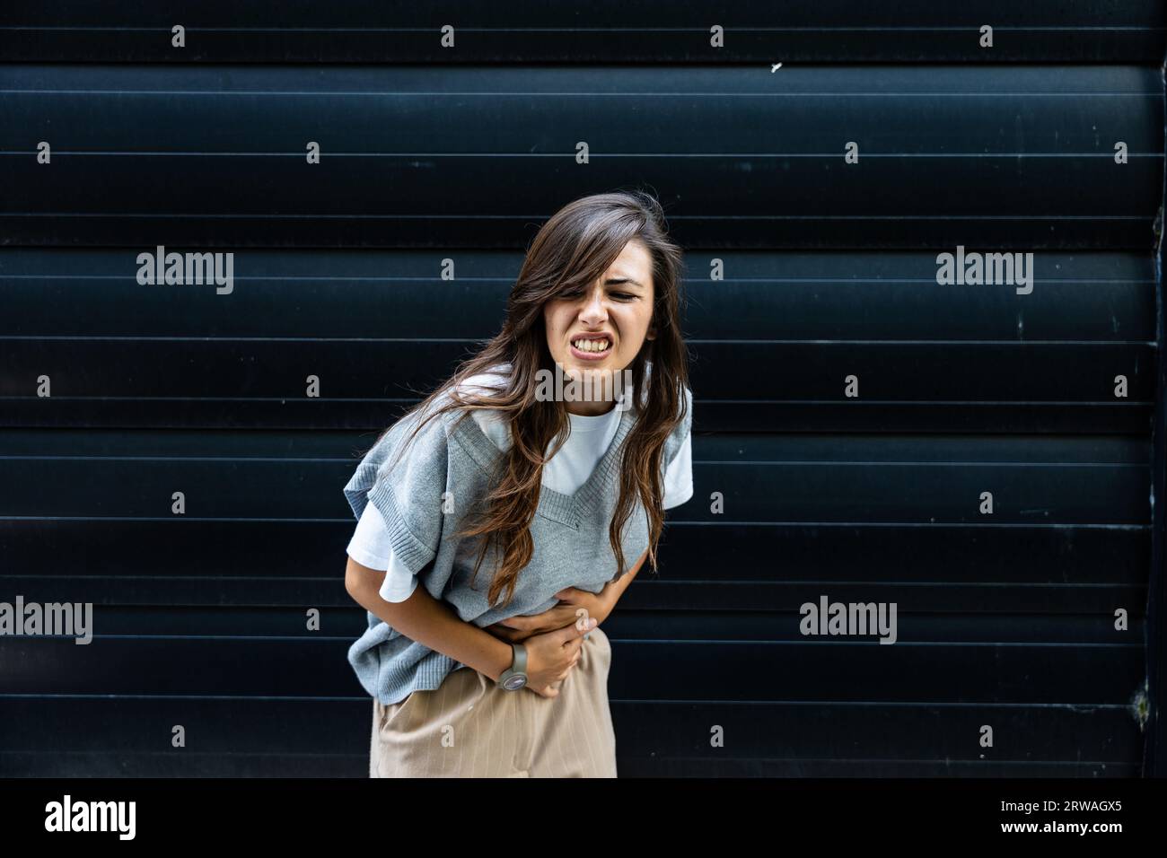 Business woman has severe abdominal pain during work with hand on ...