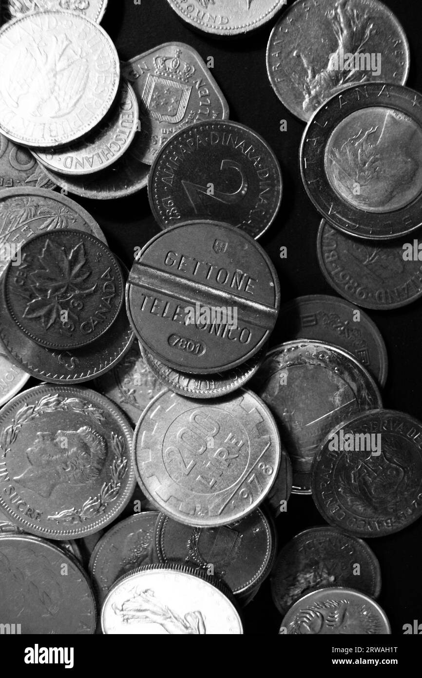 A collection of international coins and currency in a black and white ...