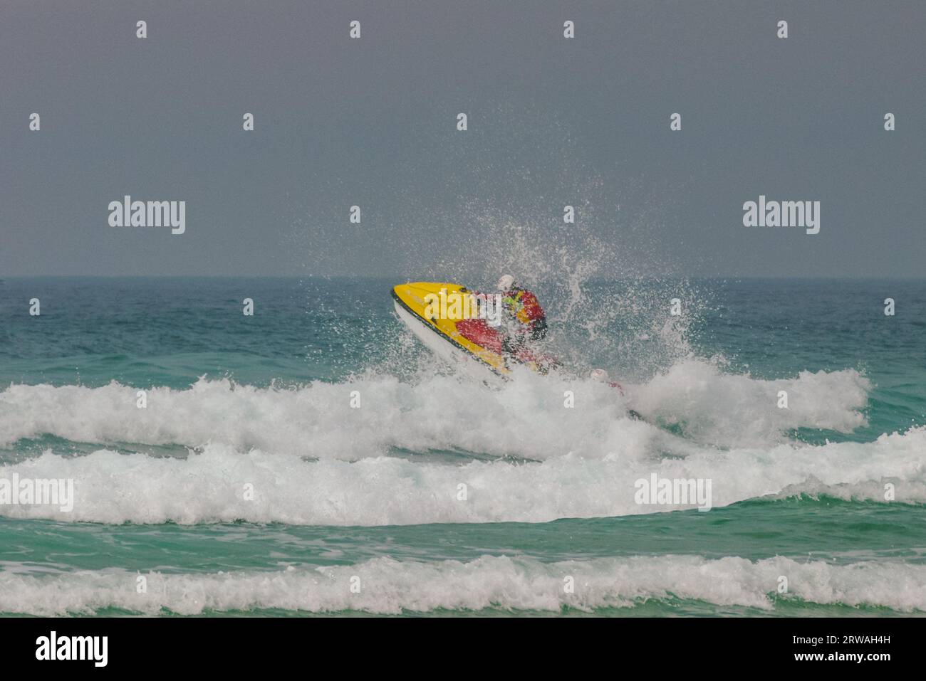 RNLI lifeguard member on Jetski heading out into rough seas off ...