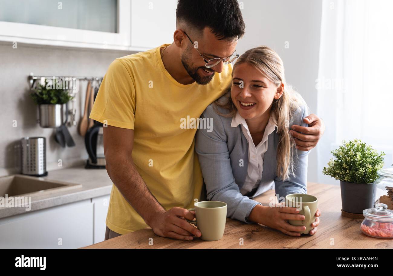 Young man and woman drinking first coffee in the kitchen in the morning ...