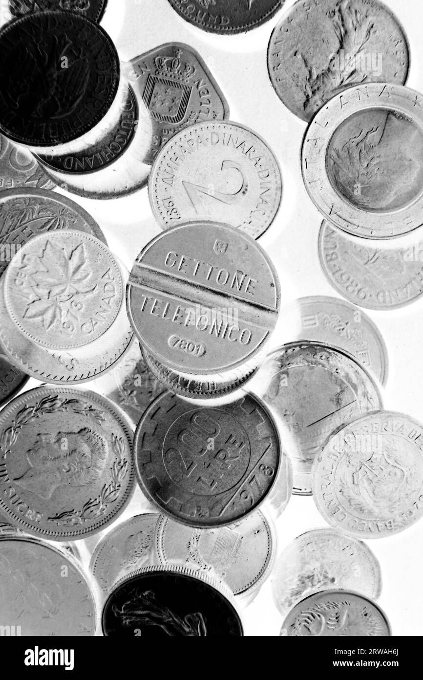 A collection of international coins and currency in a black and white ...