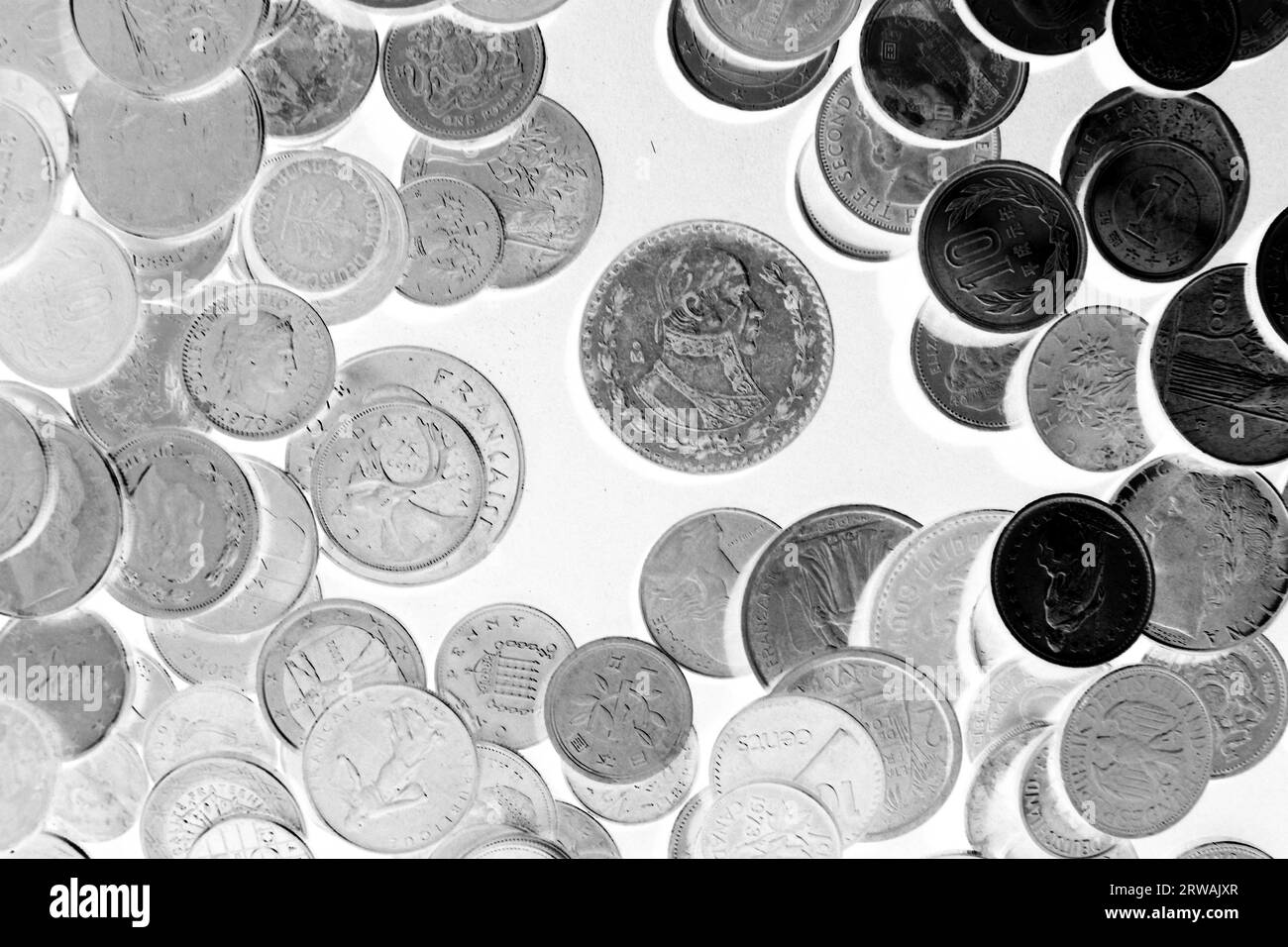 A collection of international coins and currency in a black and white ...