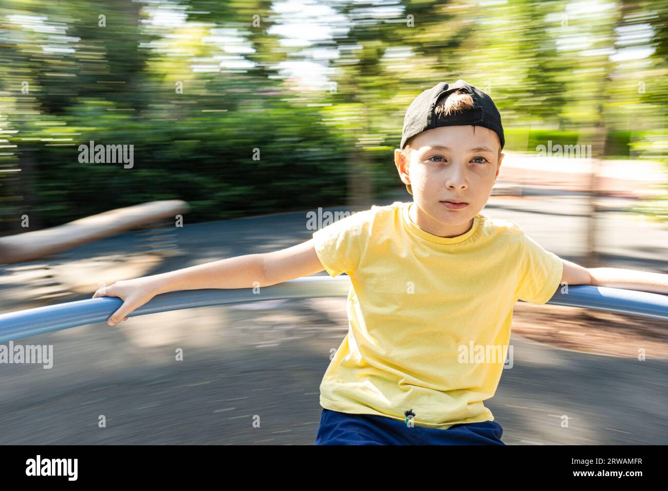 Boy spinning around on a carousel in a park in summer, Georgia Stock ...