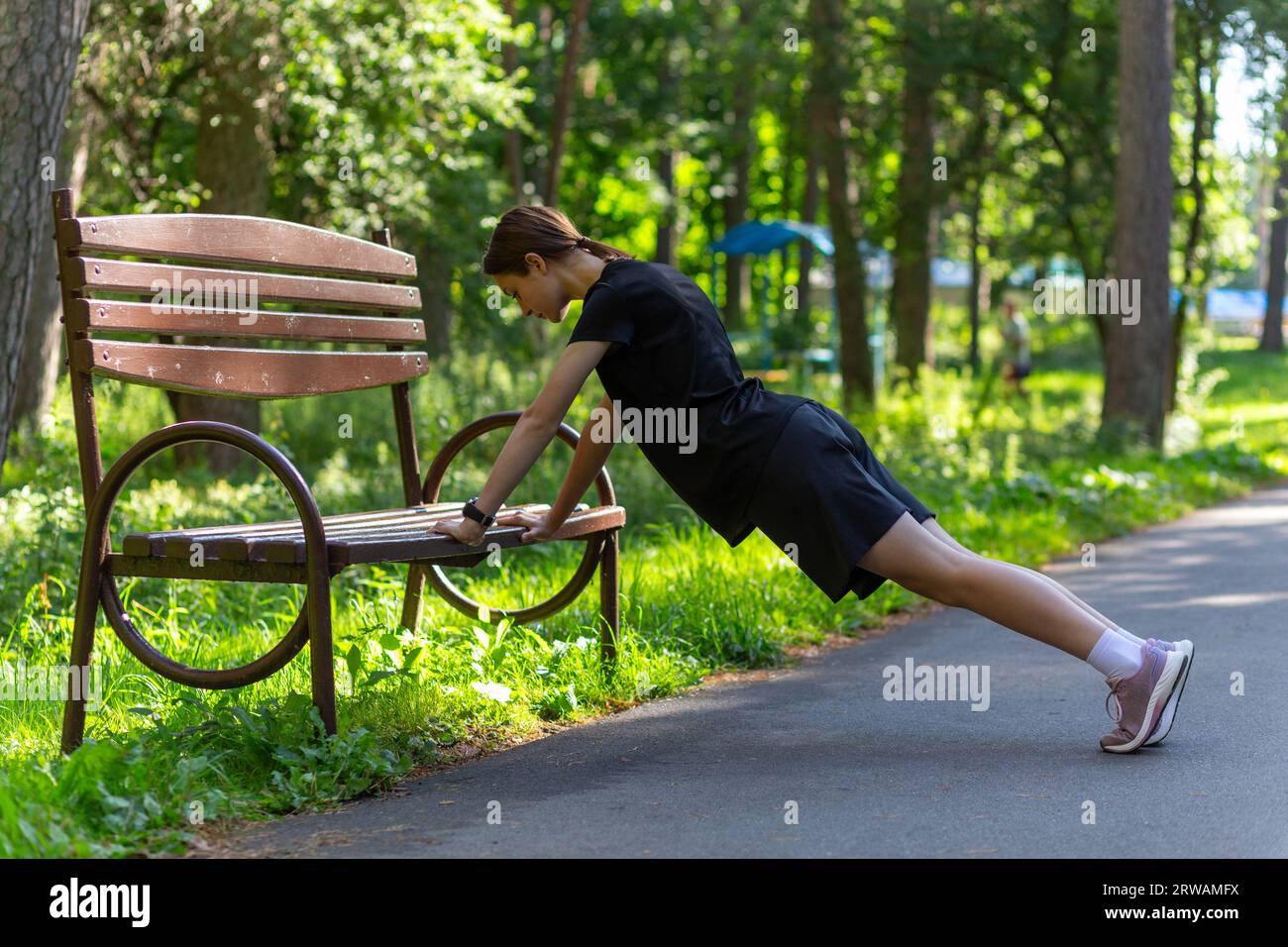 Beautiful young sporty woman in black t-shirt, black shorts and pink ...