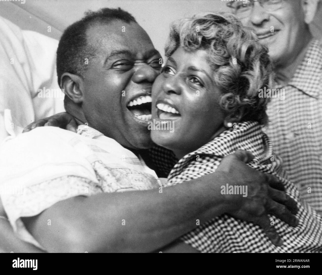 Louis Armstrong, the famed American jazz musician, hugs his wife ...