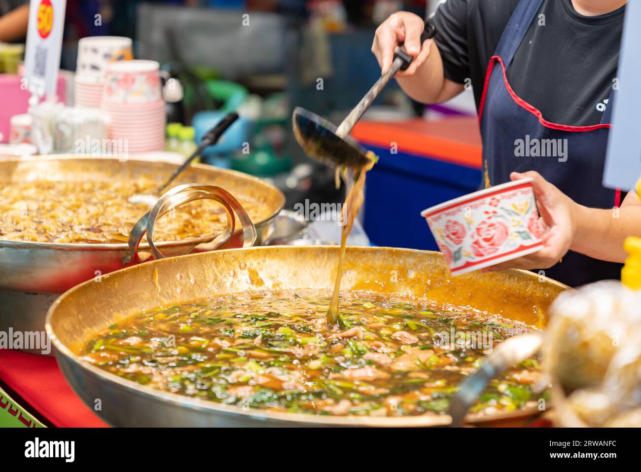 Thick gravy Chinese-Thai food style in brass pan on street food market ...