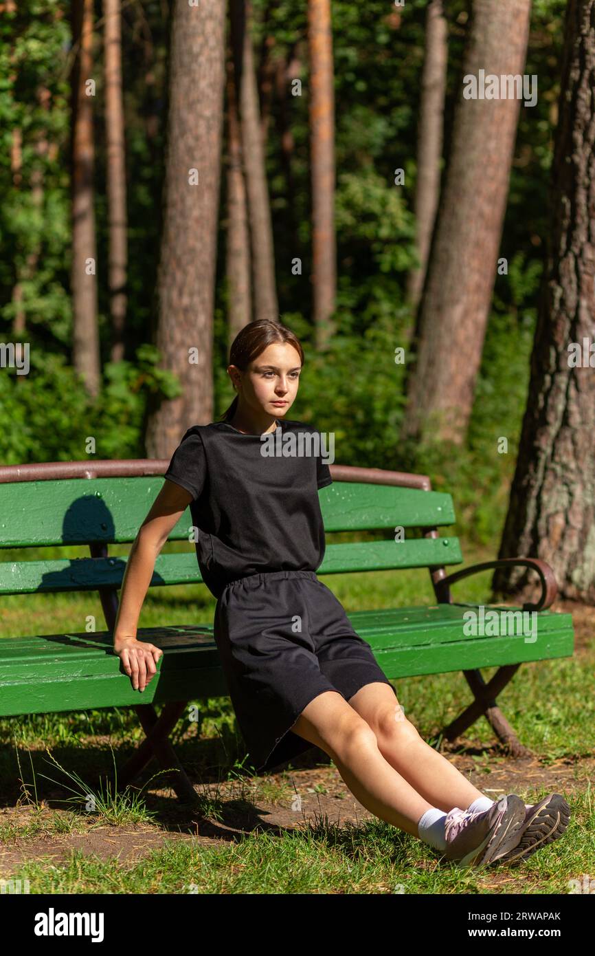 Beautiful young sporty woman in black t-shirt, black shorts and pink ...
