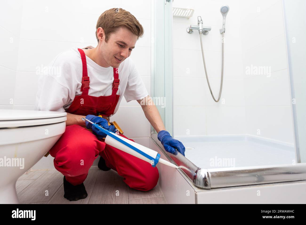 Plumber installing a shower cabin in bathroom Stock Photo - Alamy
