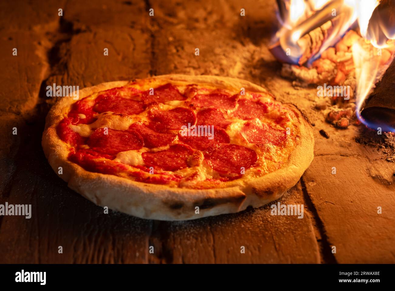 Italian pizza pepperoni in a wood-fired oven. Pizza with salami in hot ...