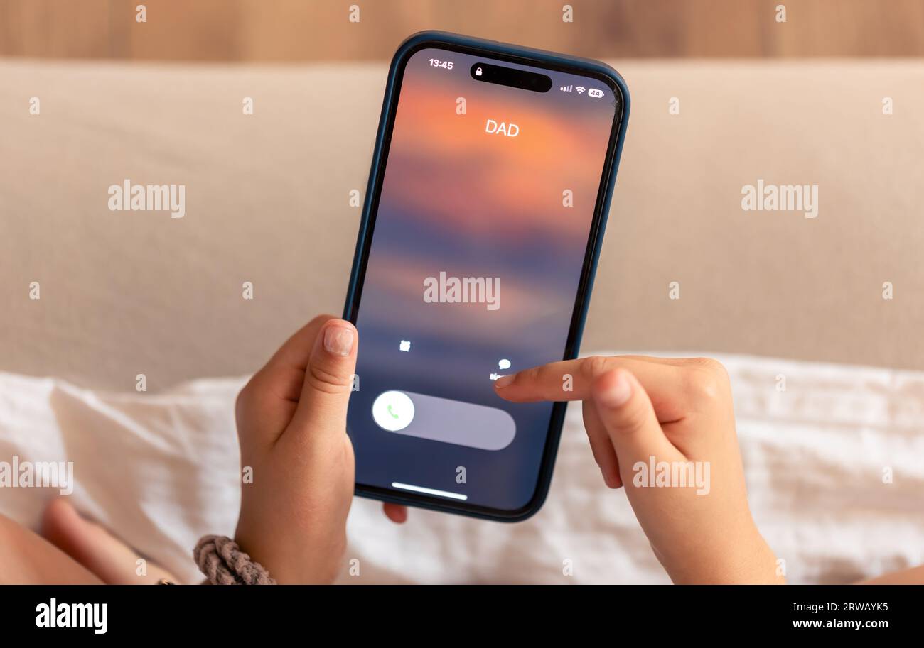 Close up of child hands holding phone with Dad's incoming call on ...