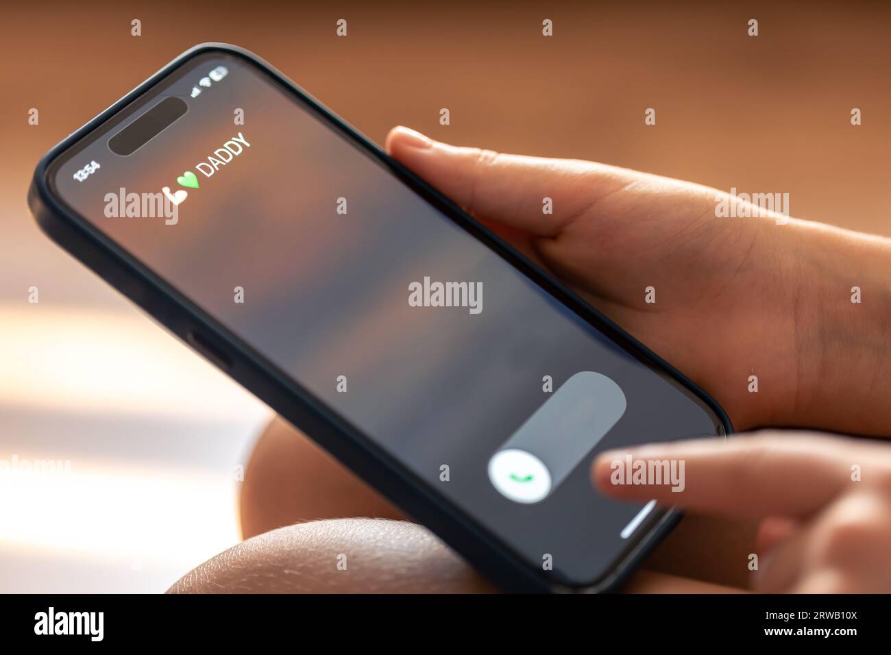 Close up of child hands holding phone with Dad's incoming call on ...