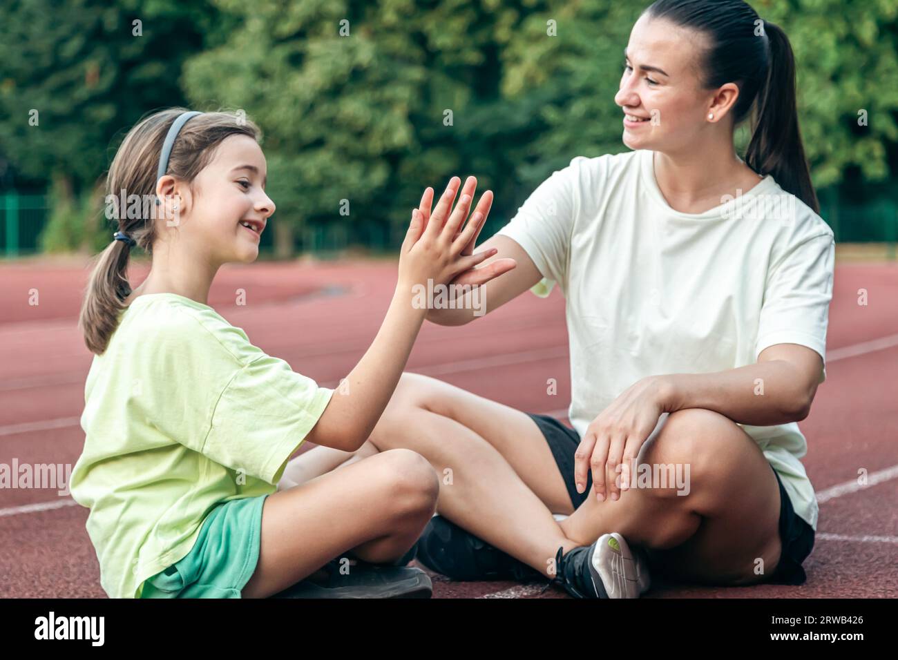 Strong mother and daughter giving high five at the stadium Stock Photo ...