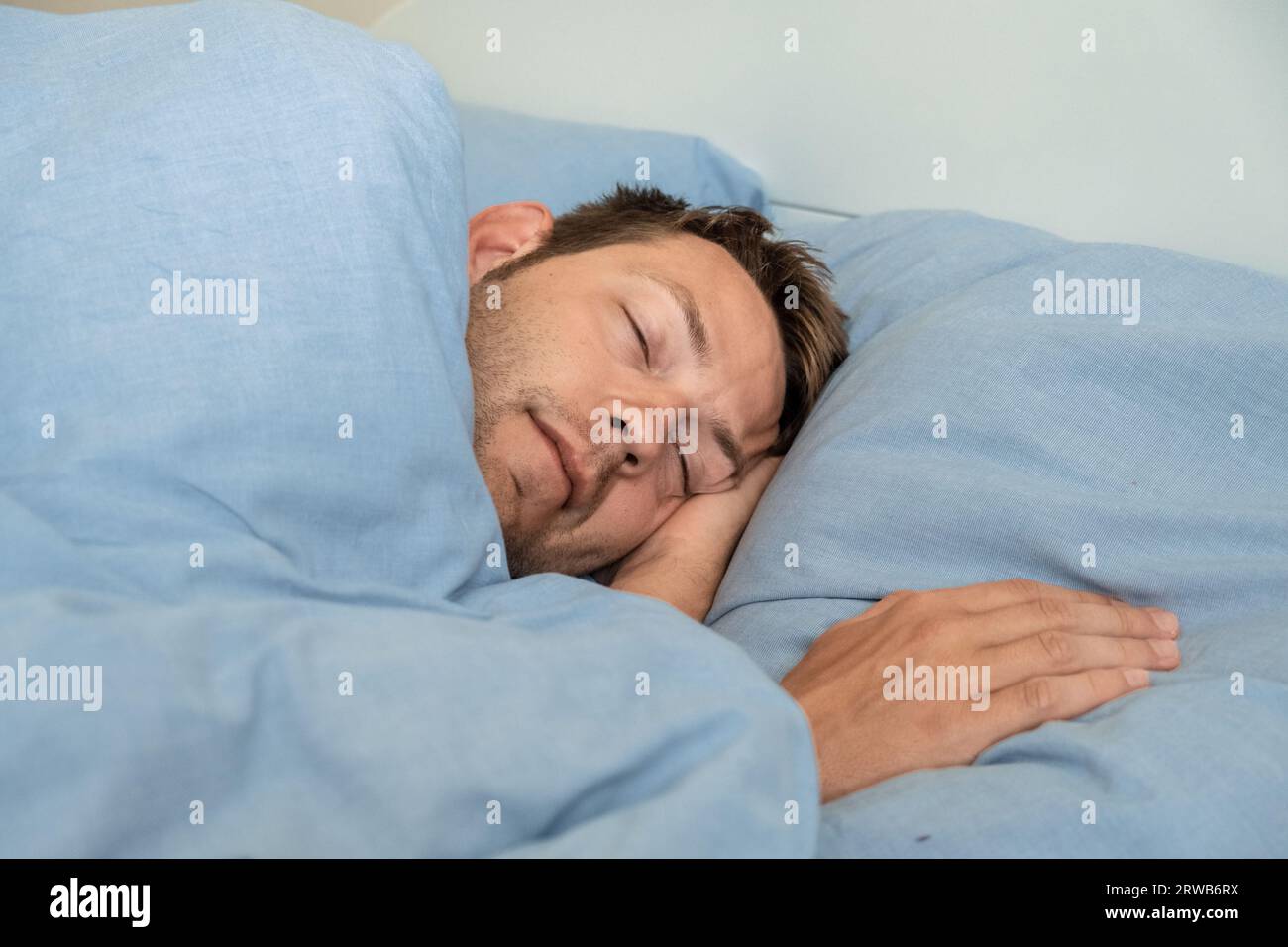 Handsome caucasian man sleeping in bed in the morning rest for healthy ...