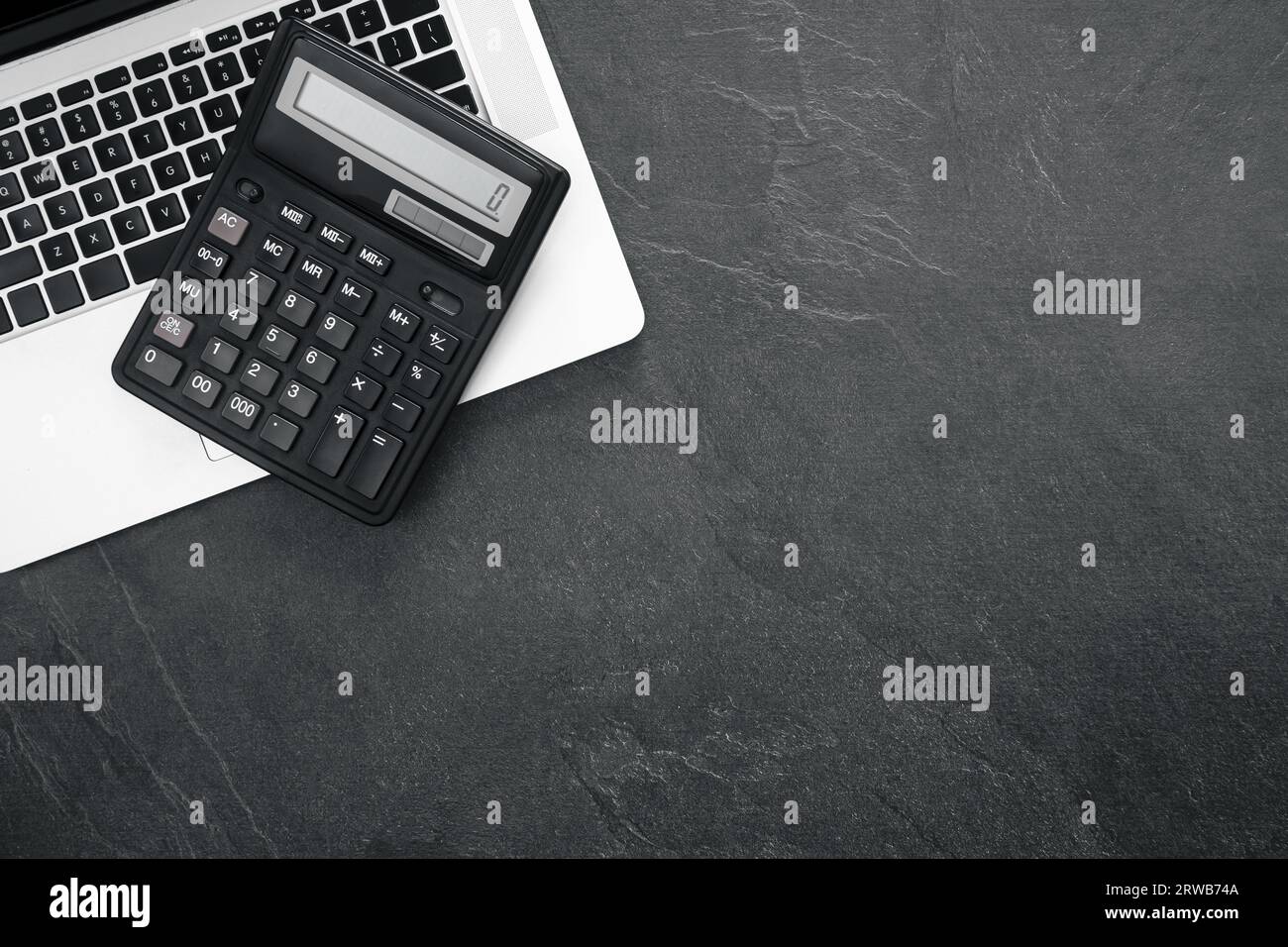 Calculator and laptop on a textured black background, top view Stock ...