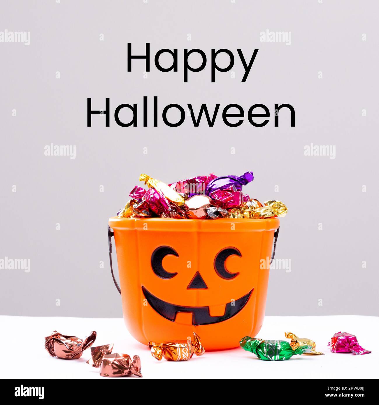 Happy halloween text on grey with jack o lantern bucket filled with ...