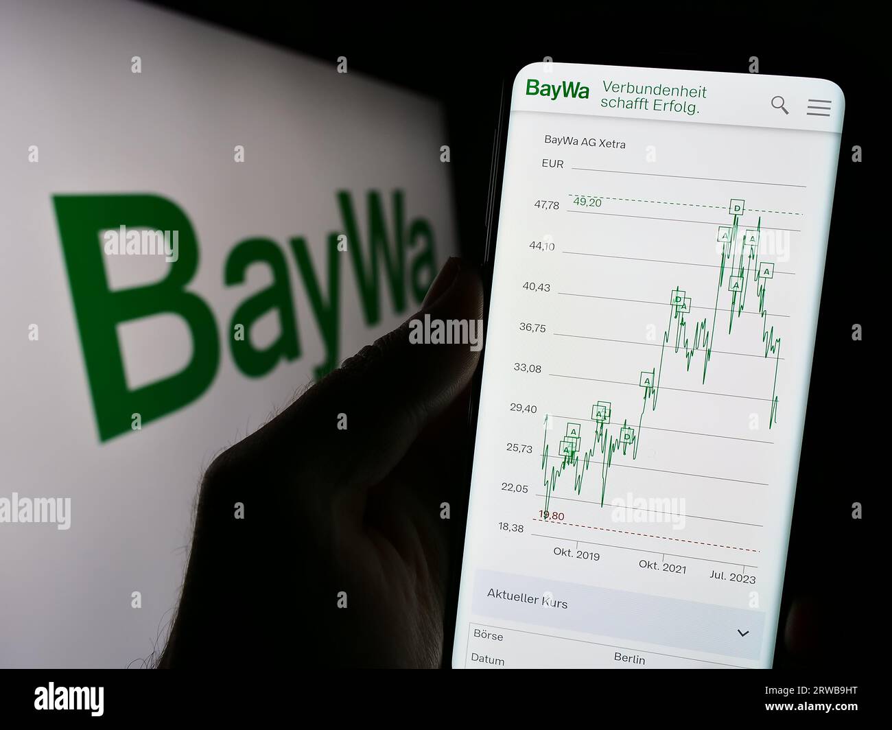 Person holding cellphone with webpage of German agribusiness company ...