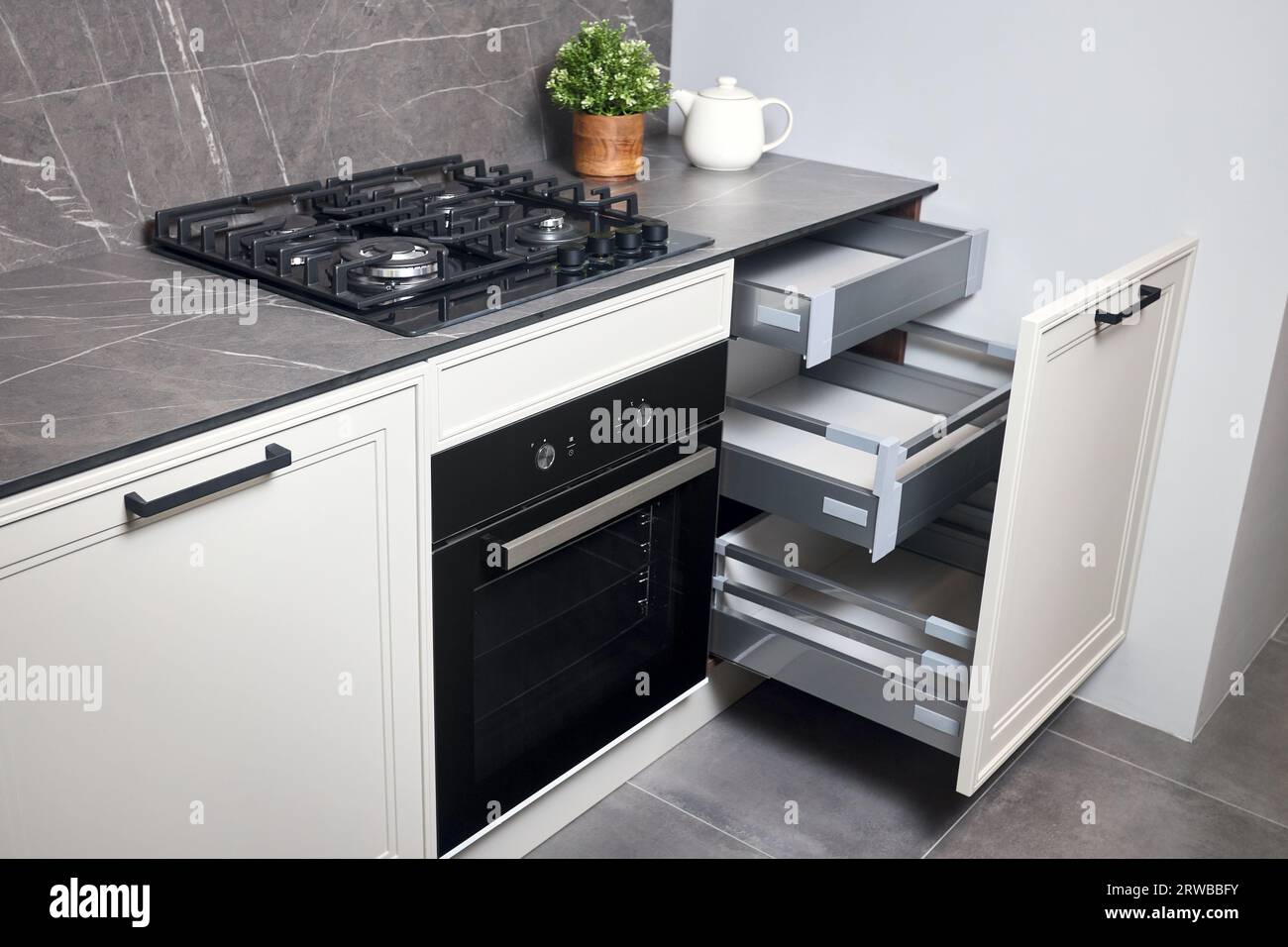 Gas cooker black glass and iron hob and hood on marble light stoneware ...