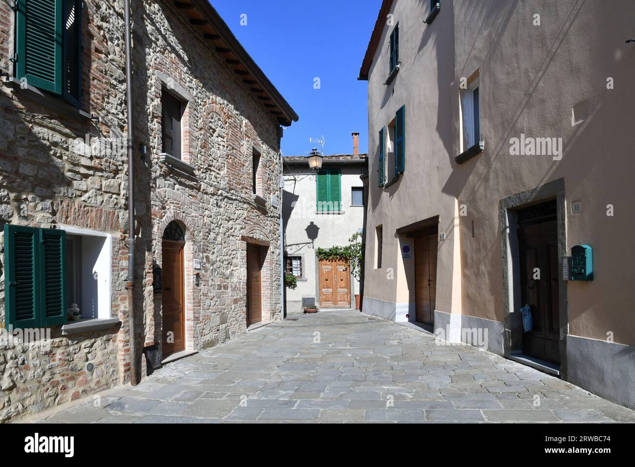 A street between the houses of Lucignano, a medieval village in Tuscany ...