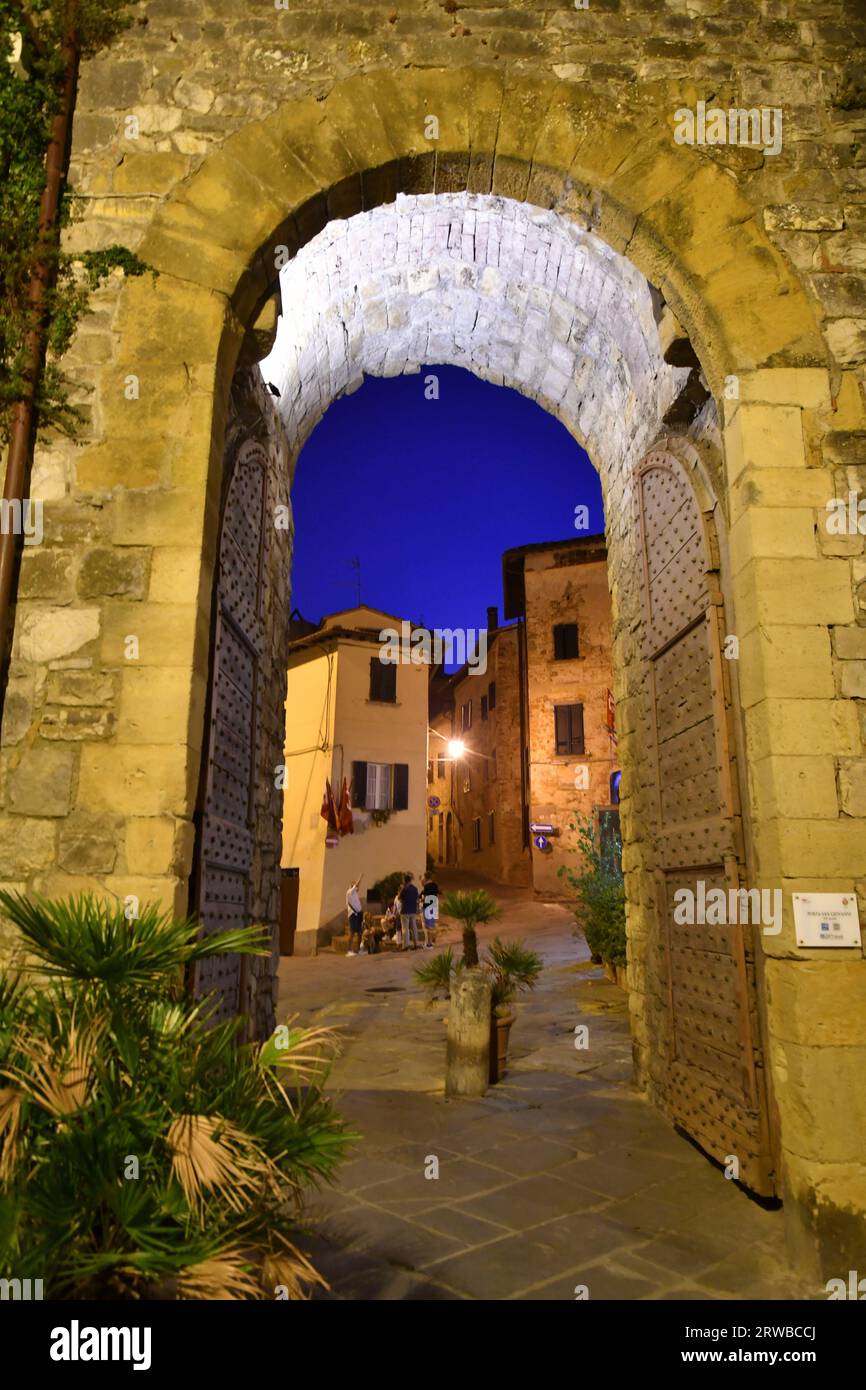 A street between the houses of Lucignano, a medieval village in Tuscany ...
