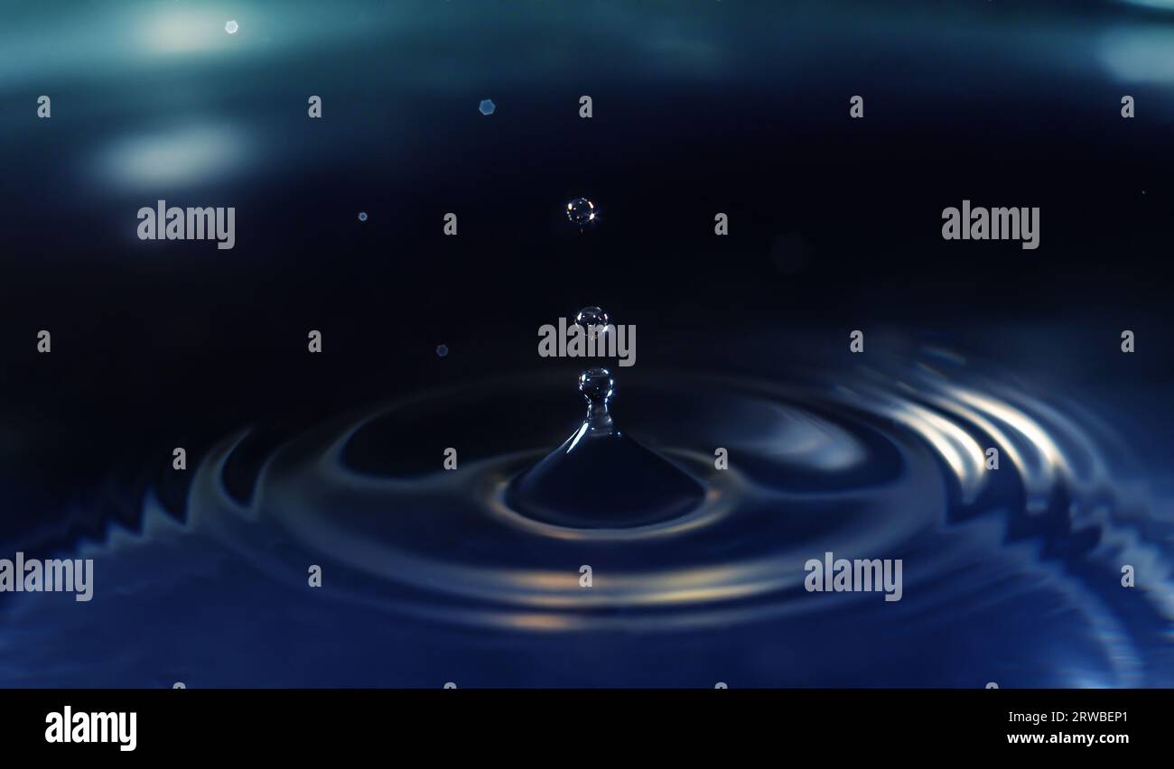 Clear aqua water droplet splashing in concentric circles, capturing ...