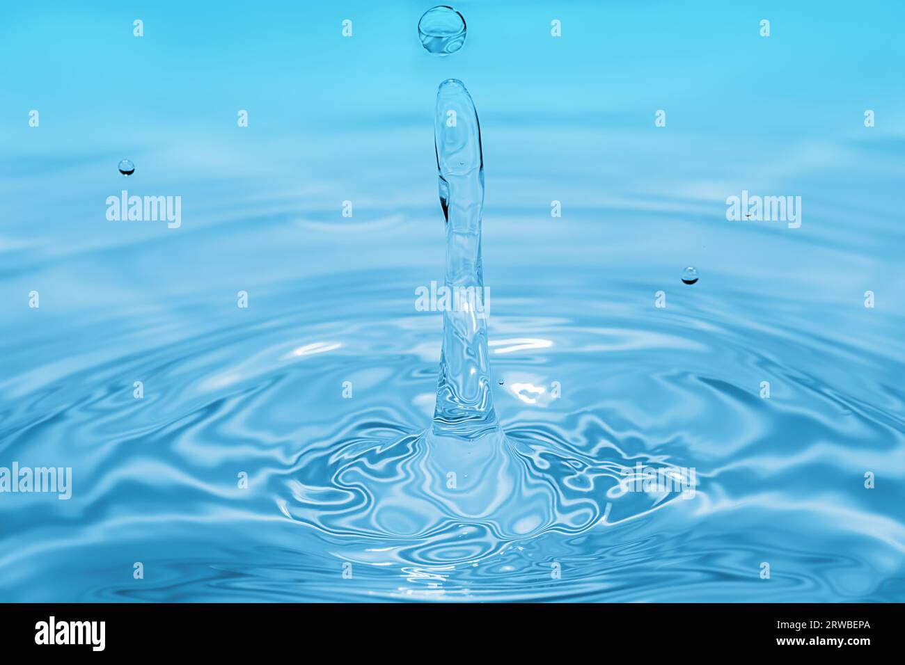 Clear aqua water droplet splashing in concentric circles, capturing ...