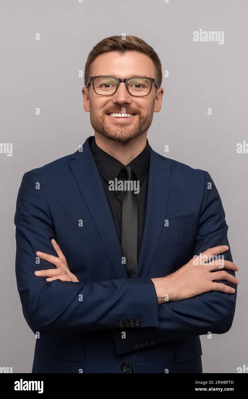 Happy successful confident businessman in suit with crossed arms on ...