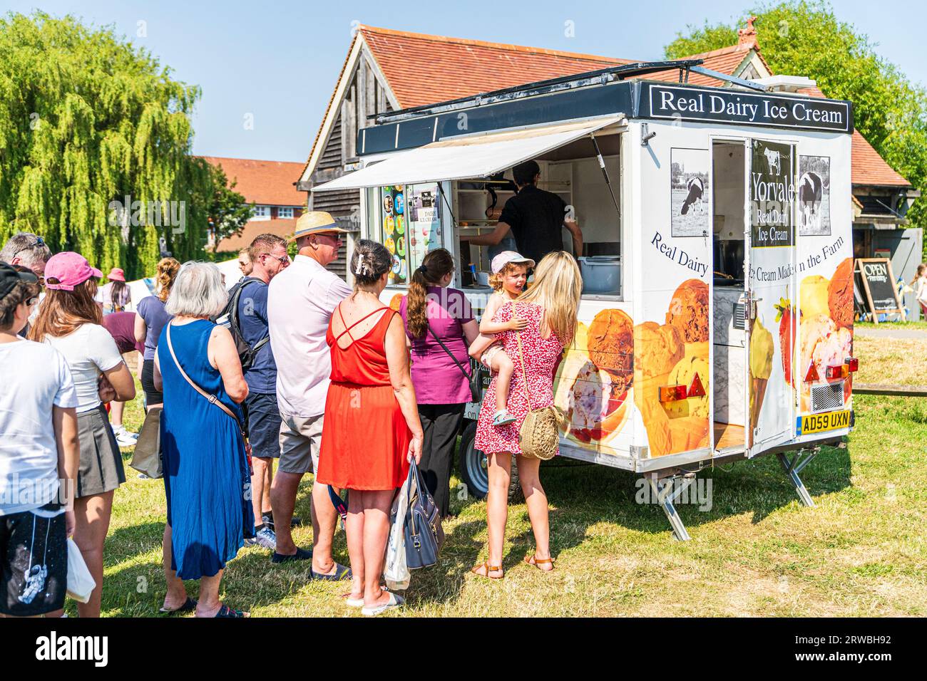 A line of people queuing up in front of a ice cream van to buy ice ...