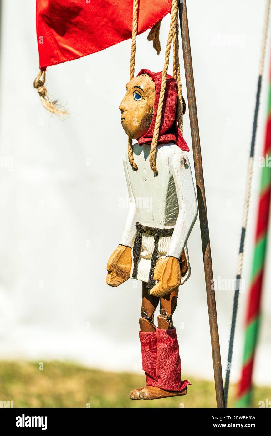 Wooden red and white puppet dressed in medieval costume hanging from a ...