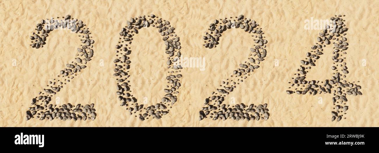Concept or conceptual 2024 year made of stones on beach sand handmade ...