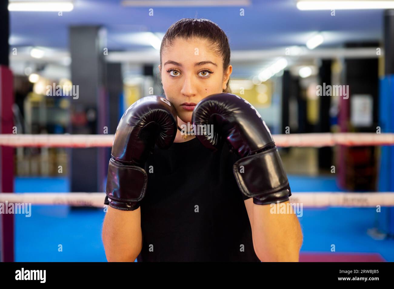 Female boxer portrait in guard position in a boxing ring. Fighting ...