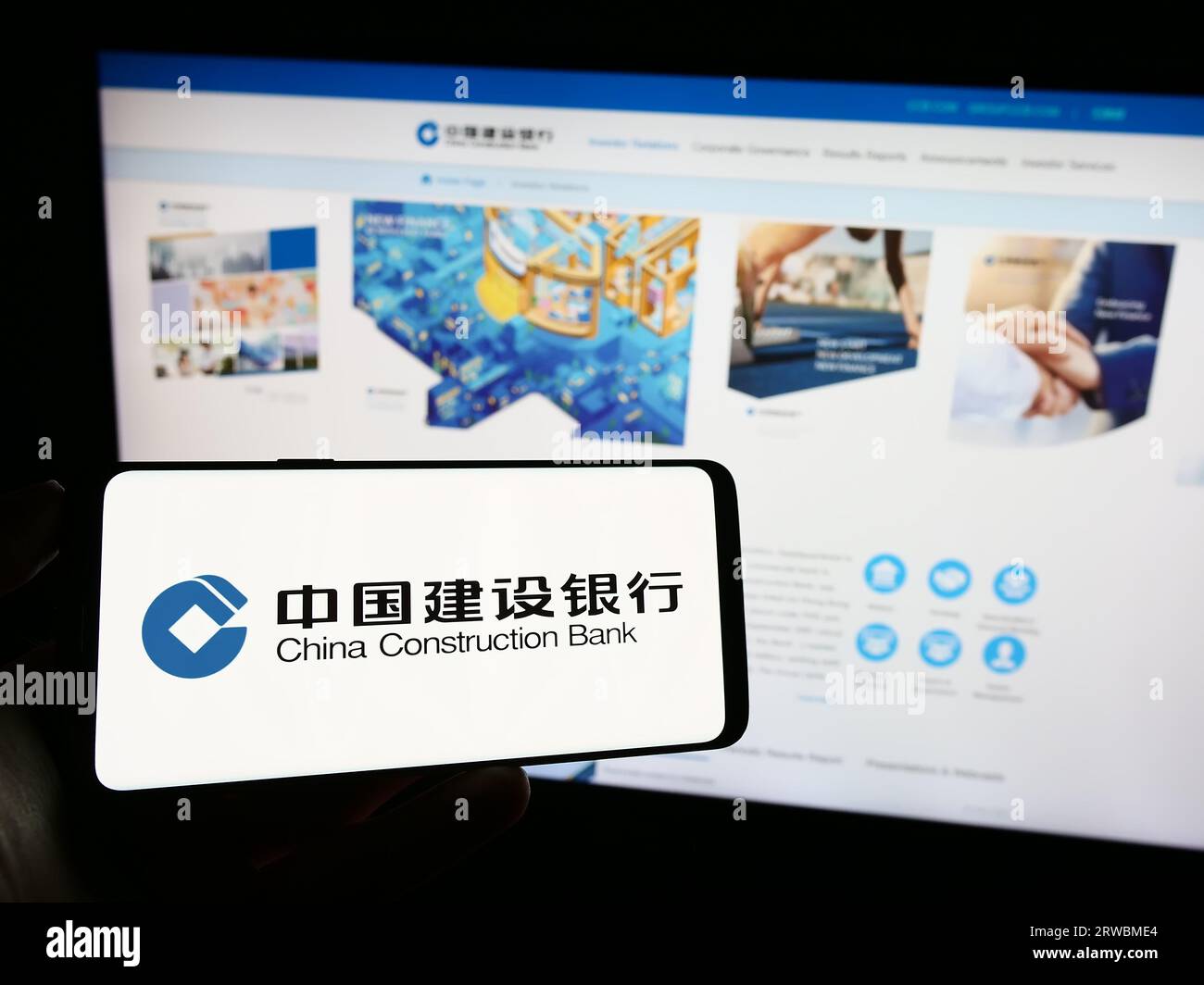 Person holding mobile phone with logo of company China Construction ...