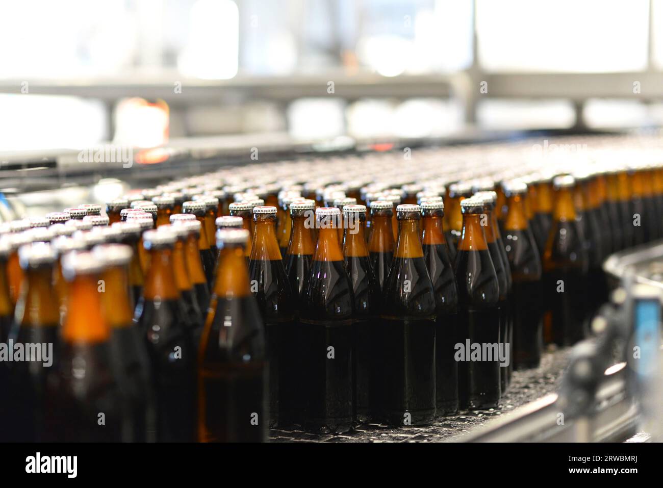 beer bottles on the assembly line in a modern brewery - industrial ...