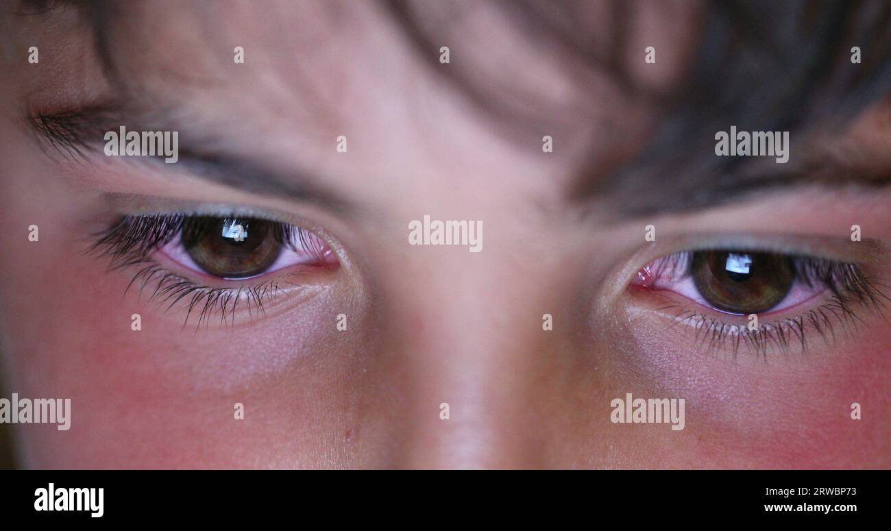 Kid macro eyes staring at screen device at night. Child boy playing ...