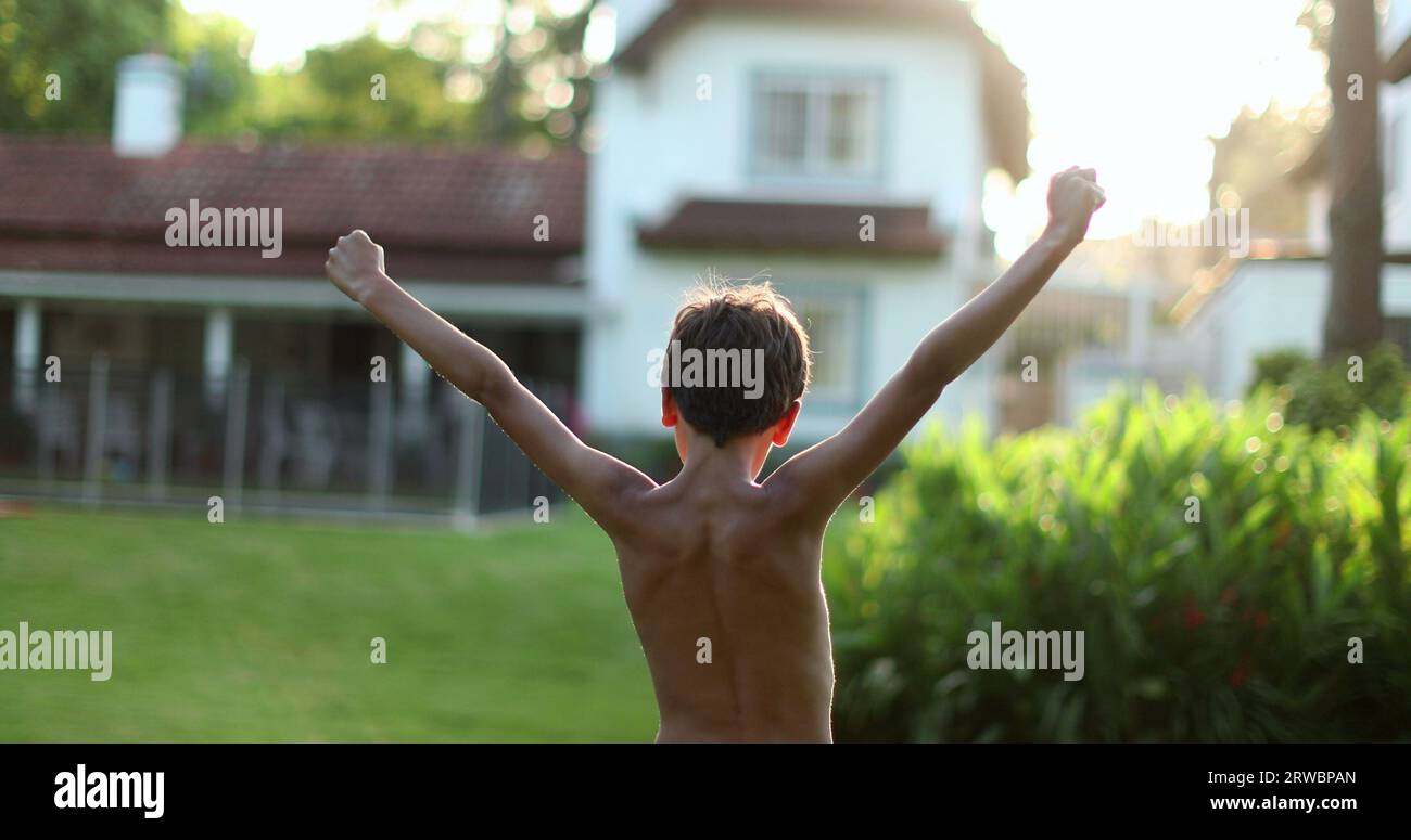 Kid raising arms in the air. Young boy child in victory stand raises ...