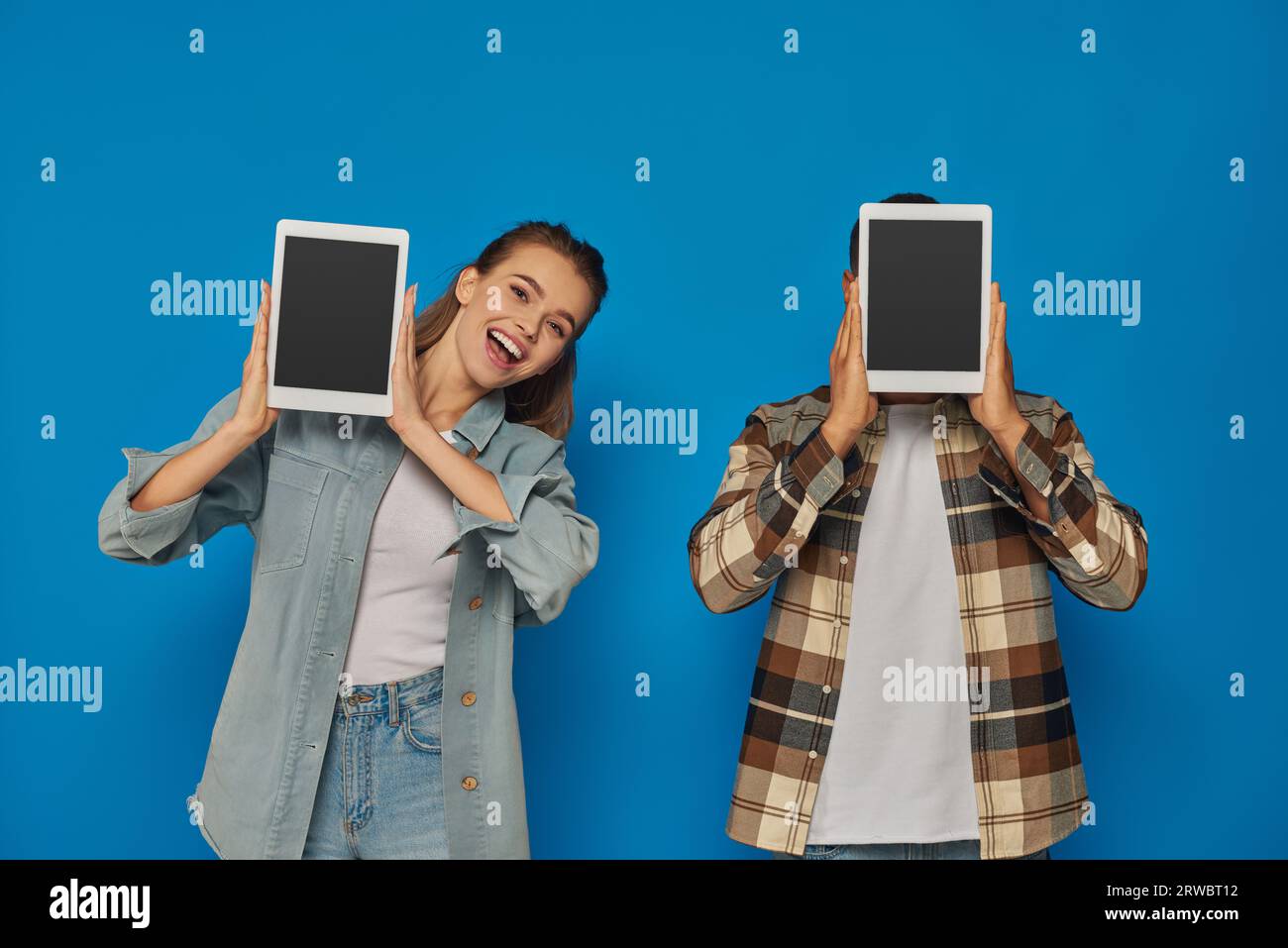 african american man obscuring face with digital tablet near excited ...