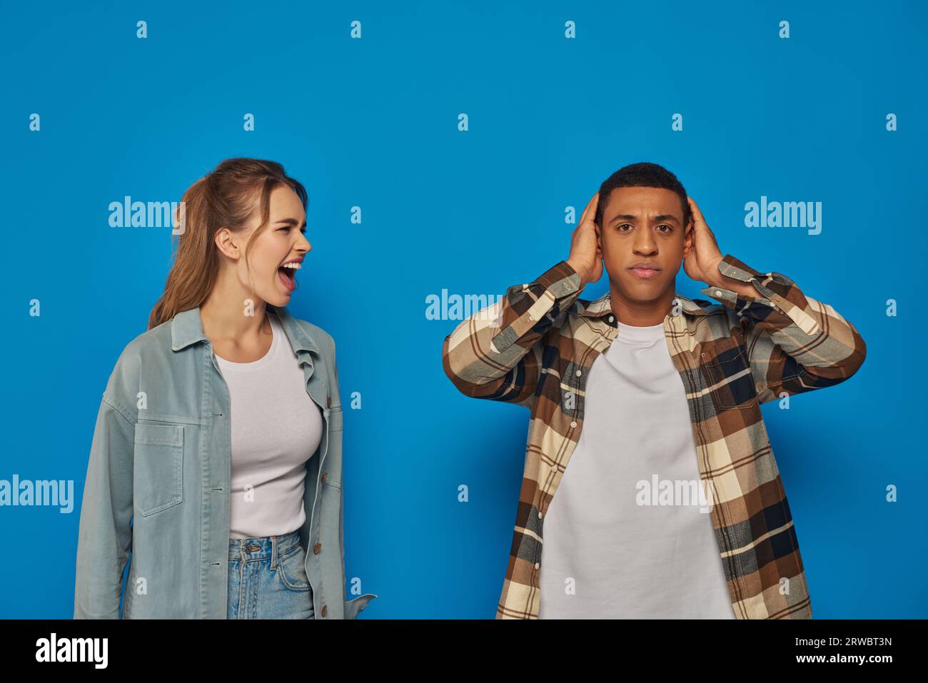 emotional woman screaming near african american man covering his ears ...