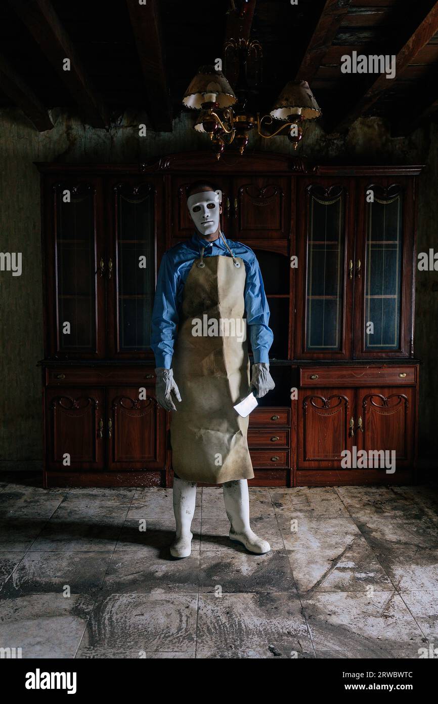 Anonymous terrifying man in butcher costume with apron and knife ...