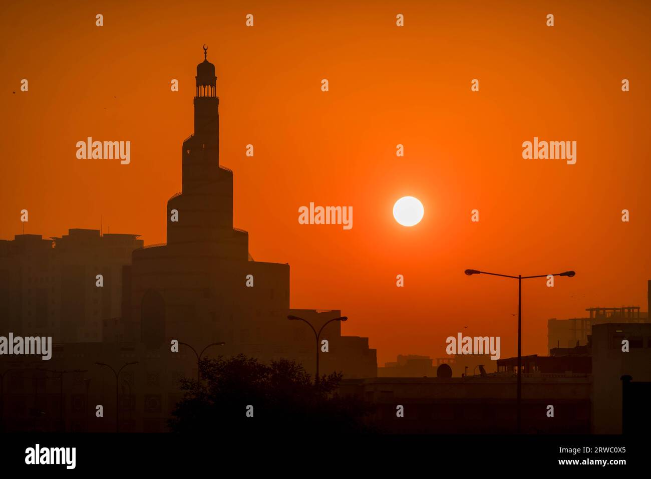 The Silhouette Al Fanar tower mosque during the beautiful sunset in ...