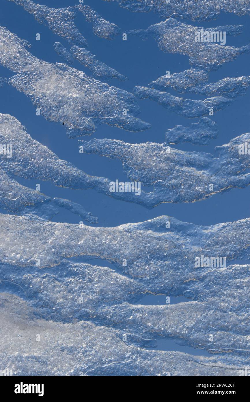 Melting snow and ice forms cloud-like patterns on a skylight window ...