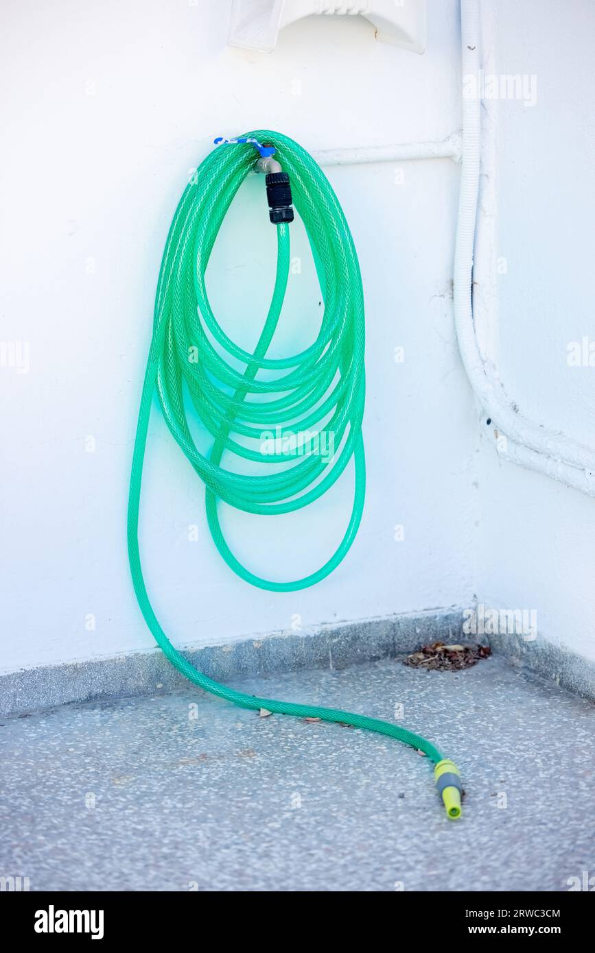 Blue water pipes rolled,blue watering hose rolled on a cement wall ...