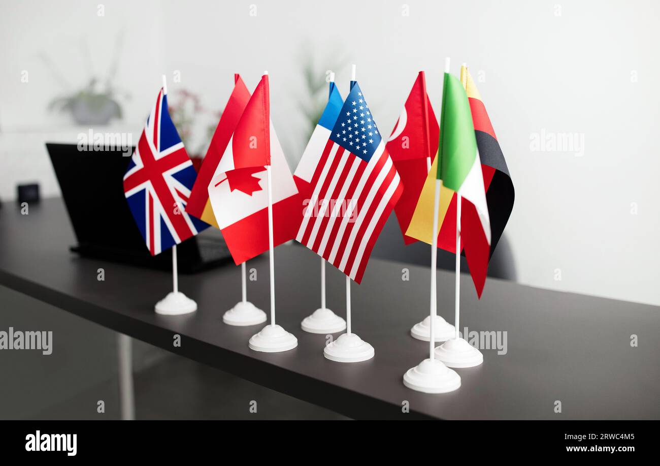 Many Different Countries Flags And Laptop Standing On Office Table ...