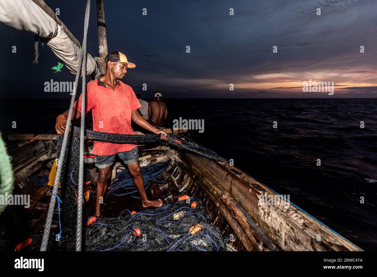 Night fishing. A man pulls out a fishing net at night. Indian Ocean ...