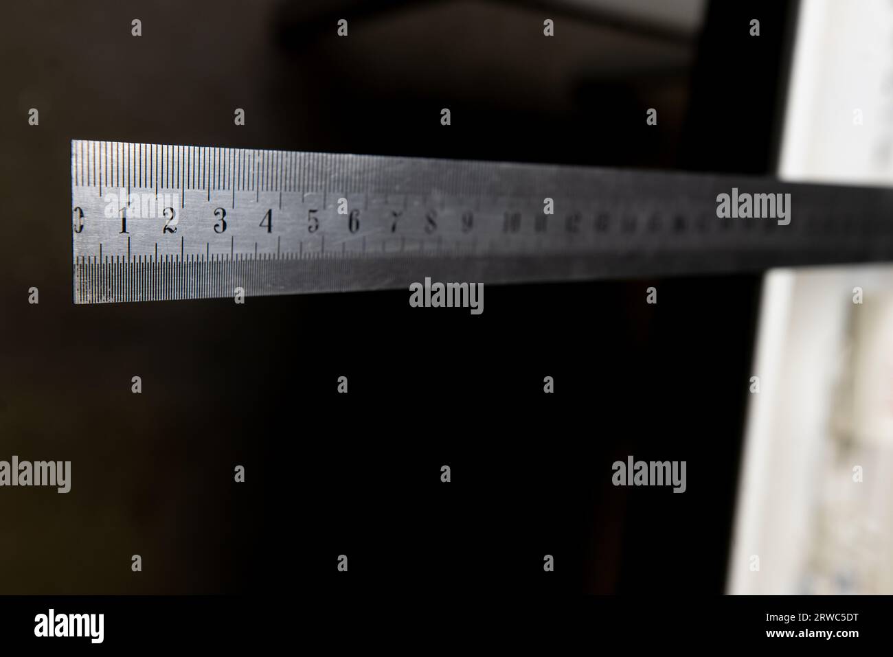 iron ruler with numbers on black background Stock Photo - Alamy