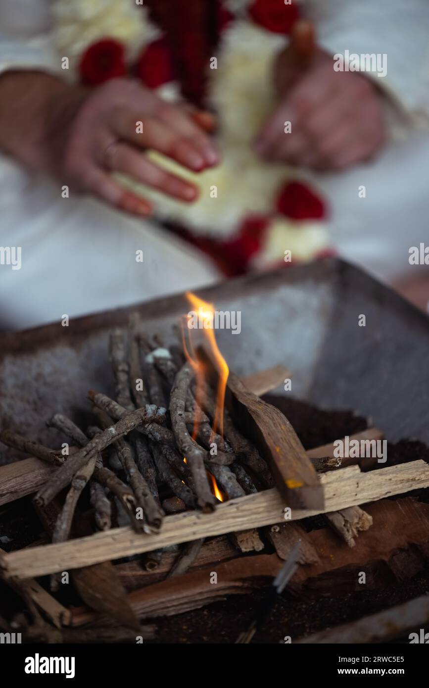 During an Indian wedding, a priest performs a ritual with fire and wood ...