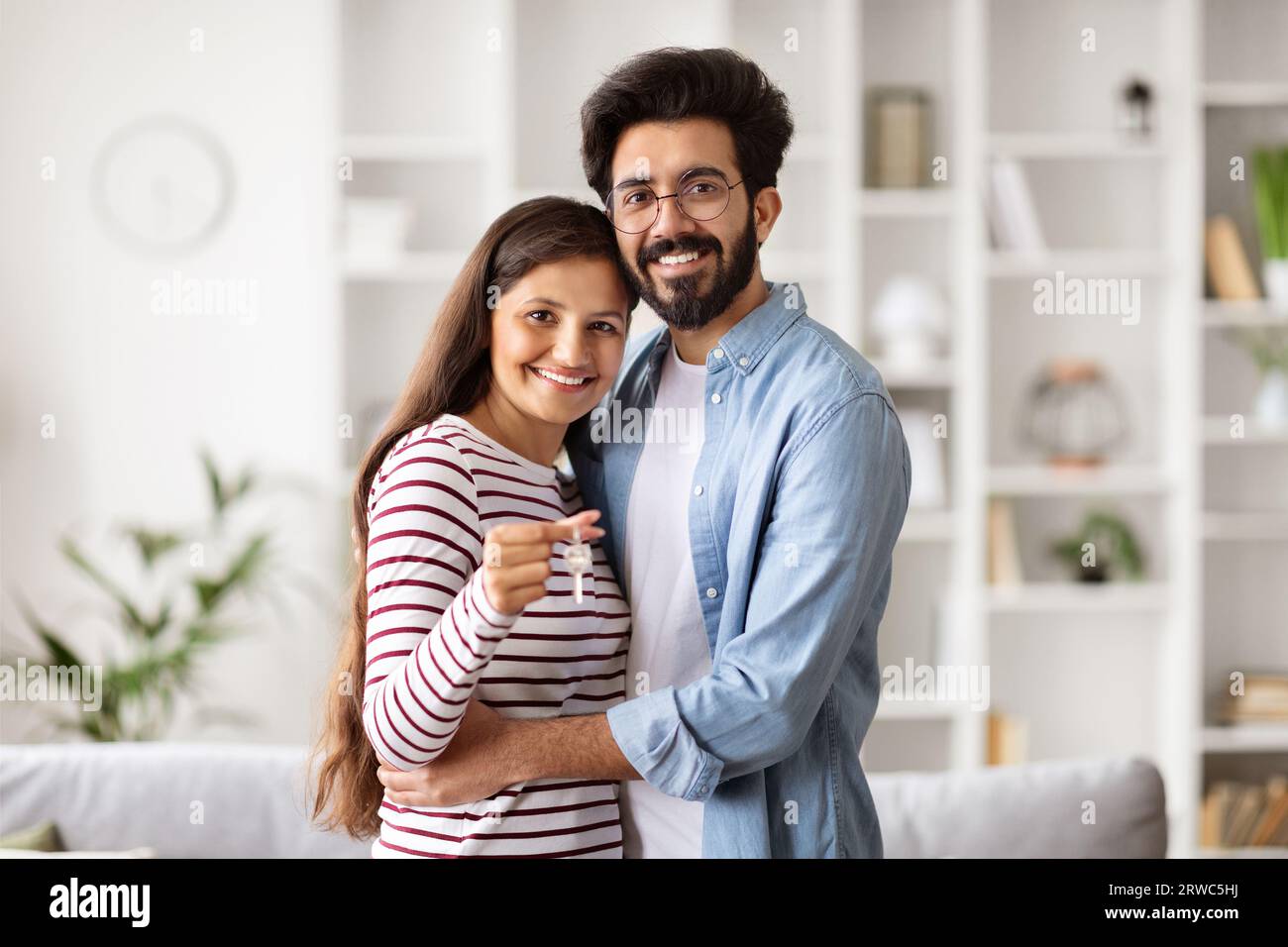 Happy indian couple at new home, holding house keys Stock Photo - Alamy