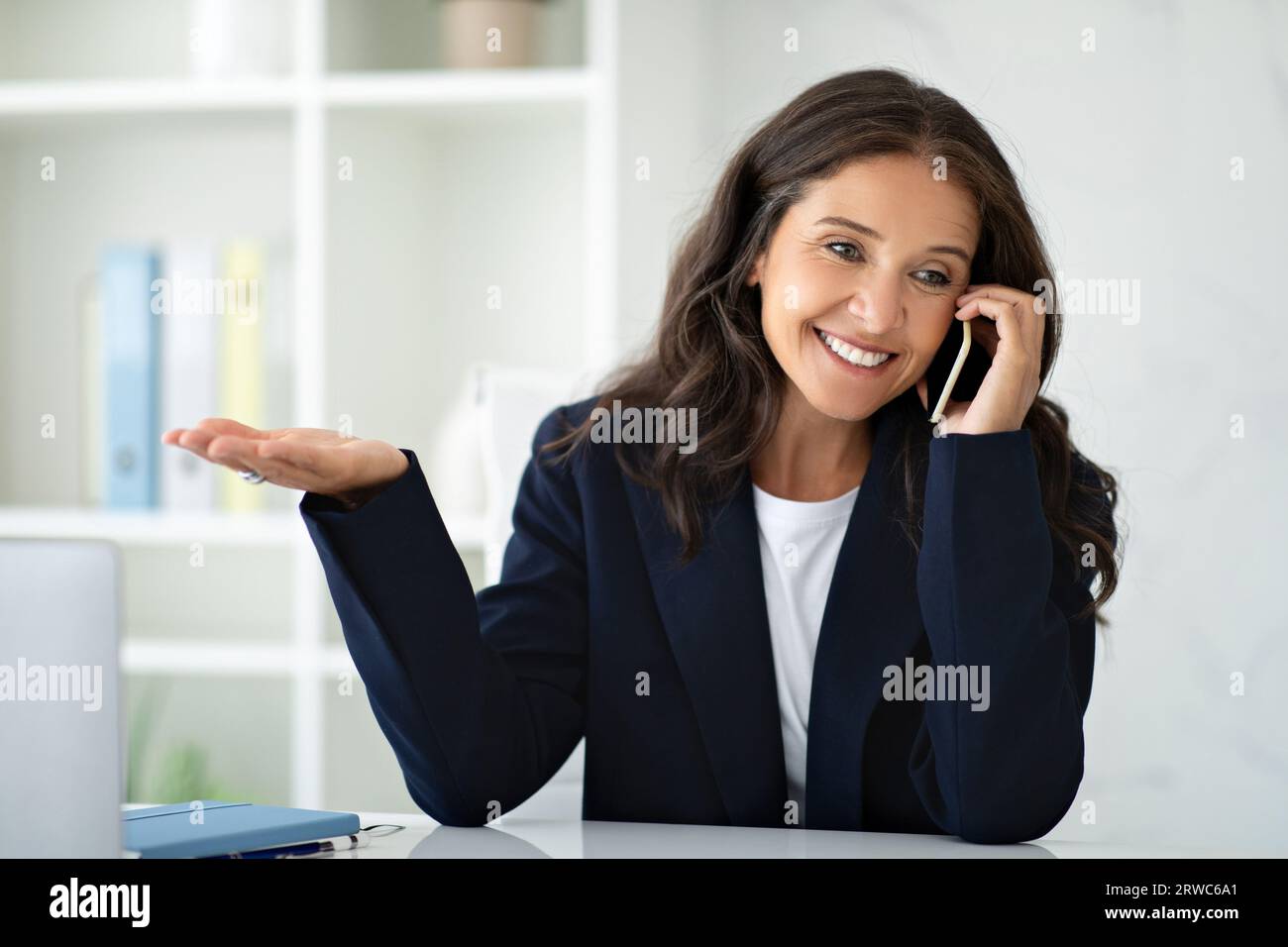 Positive attractive mature lady professional have phone call at office ...