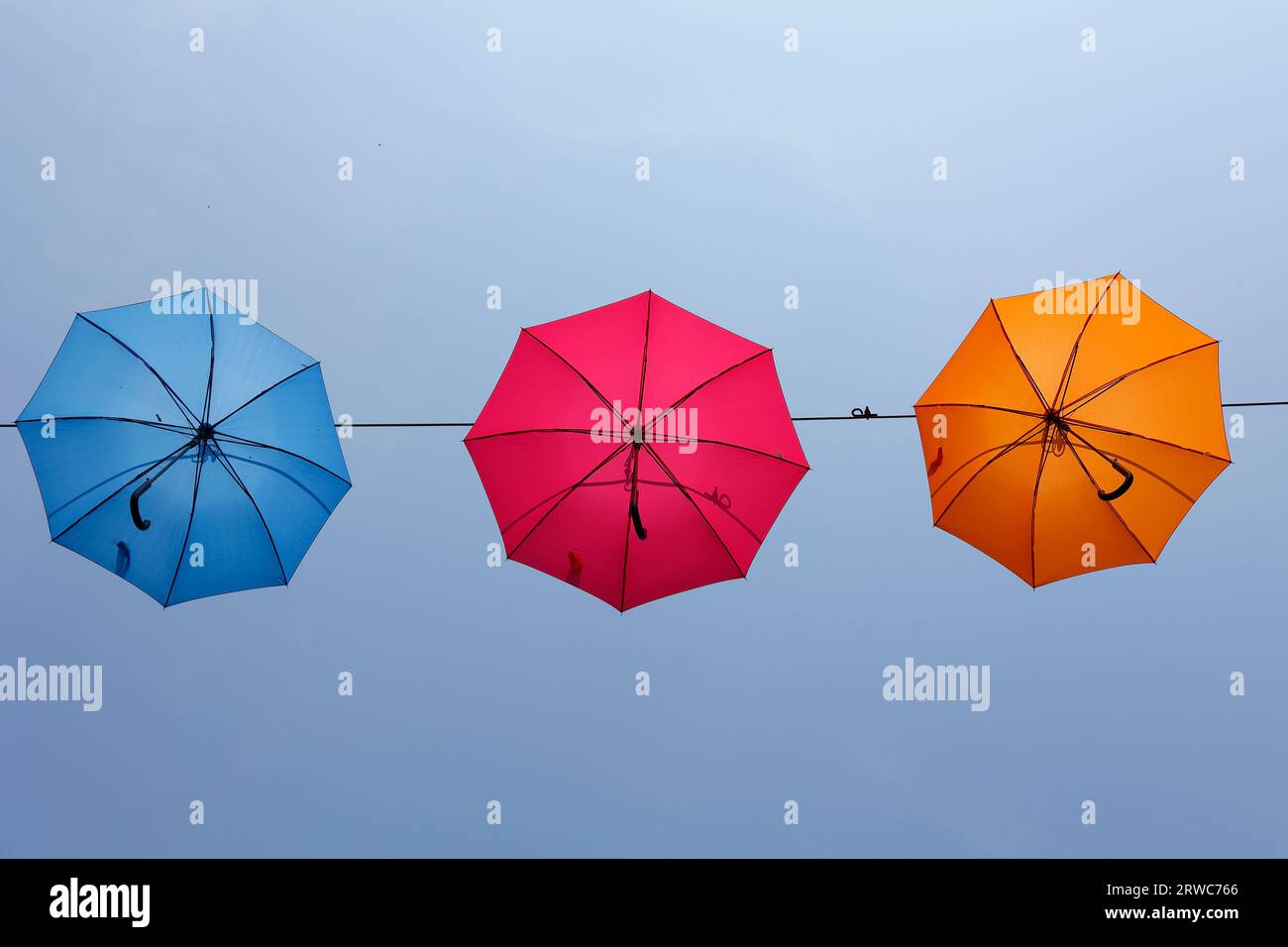 Umbrellas hanging from a rope photographed from below Stock Photo - Alamy